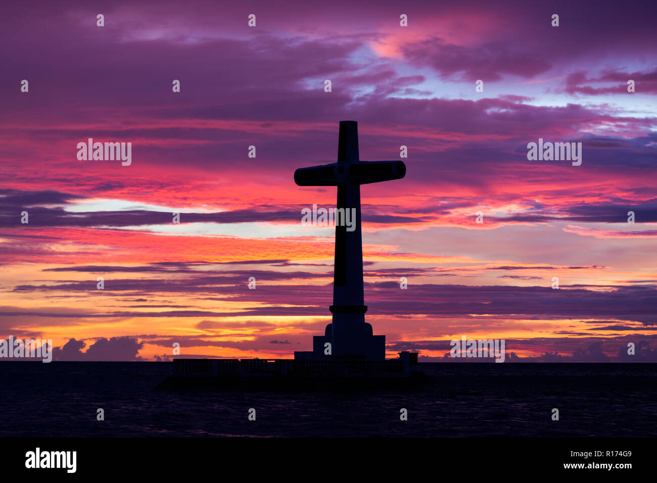 Catholic cross silhouette in the sunken cemetery at dusk, Camiguin ...
