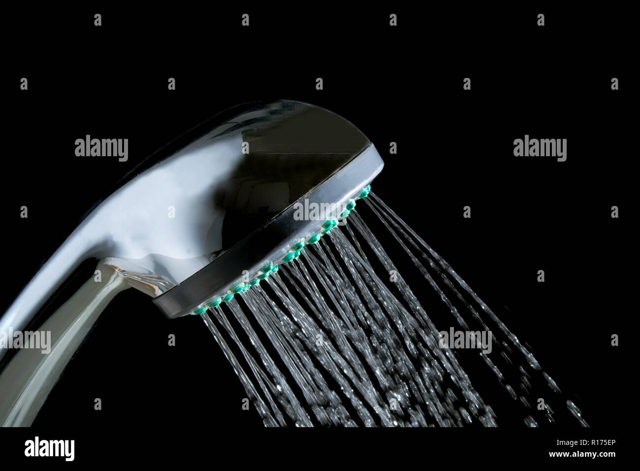 Modern hot shower with stream of water closeup isolated on black ...