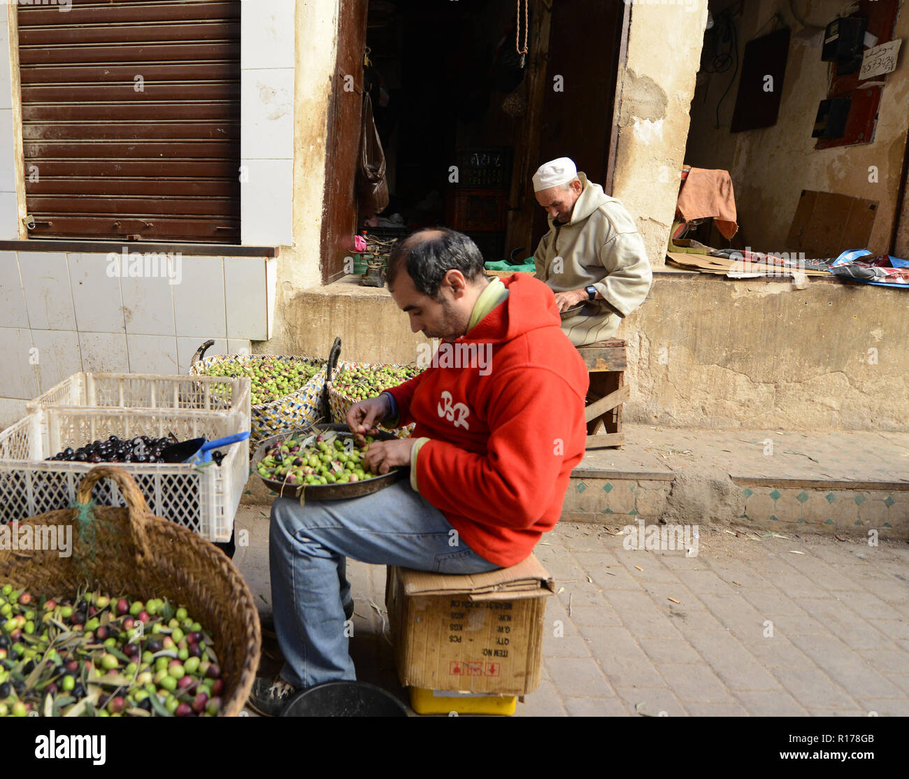 Moroccan man grading newly picked olives in the old city of Fez Stock ...