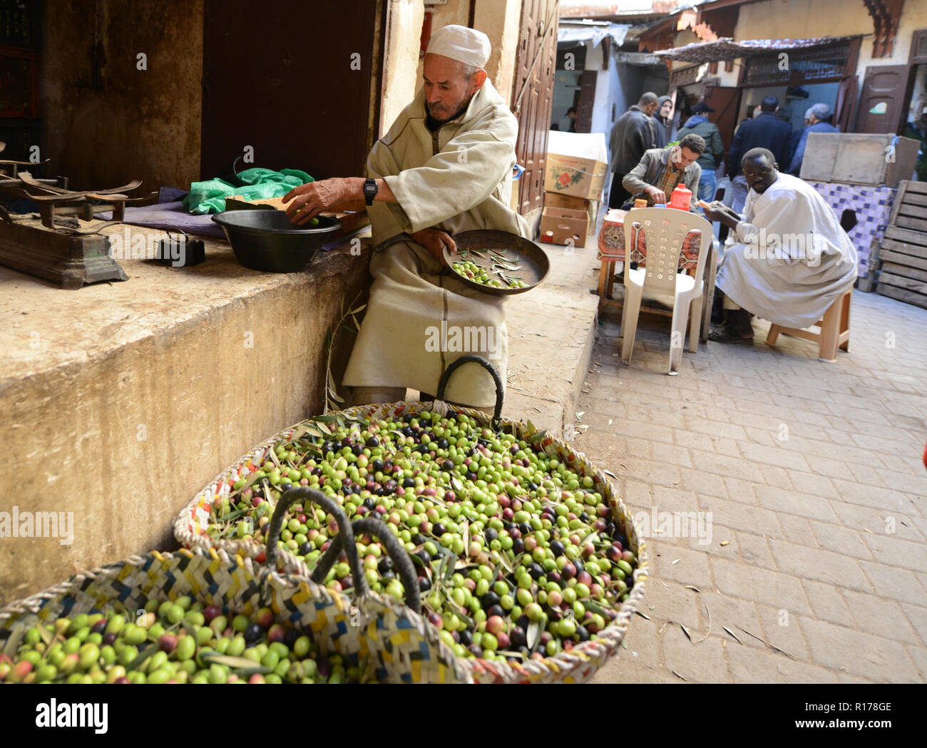 Moroccan man grading newly picked olives in the old city of Fez Stock ...