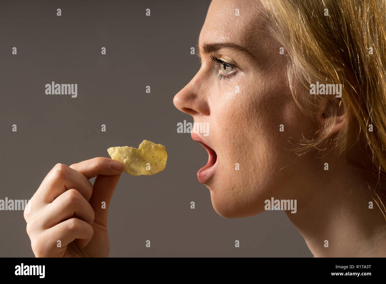 Teen girl eating chips hi-res stock photography and images - Alamy