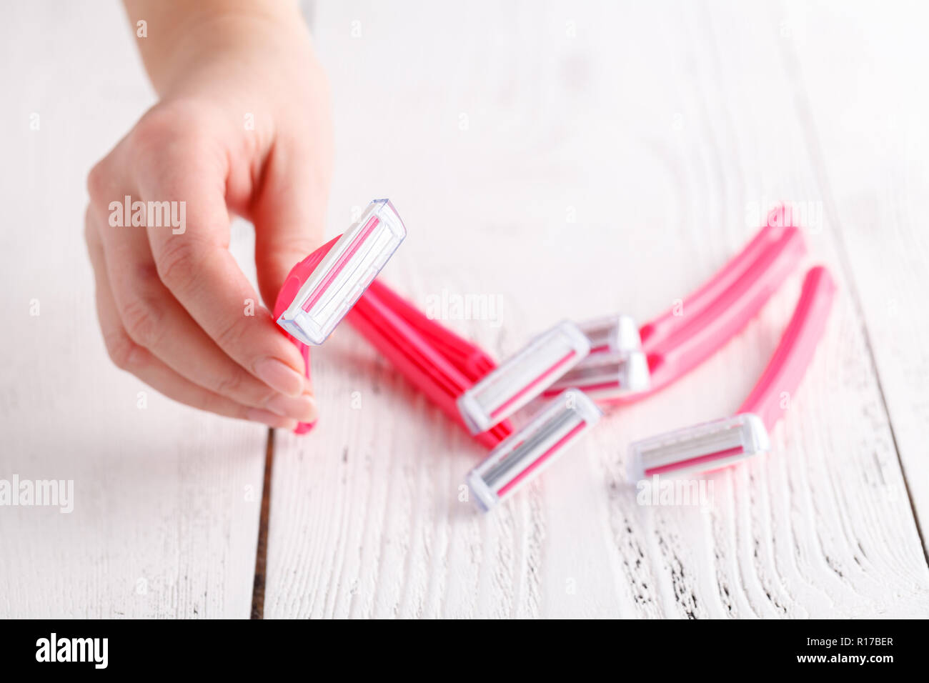 Pink female razors in hands on the white background. Set of razors on ...