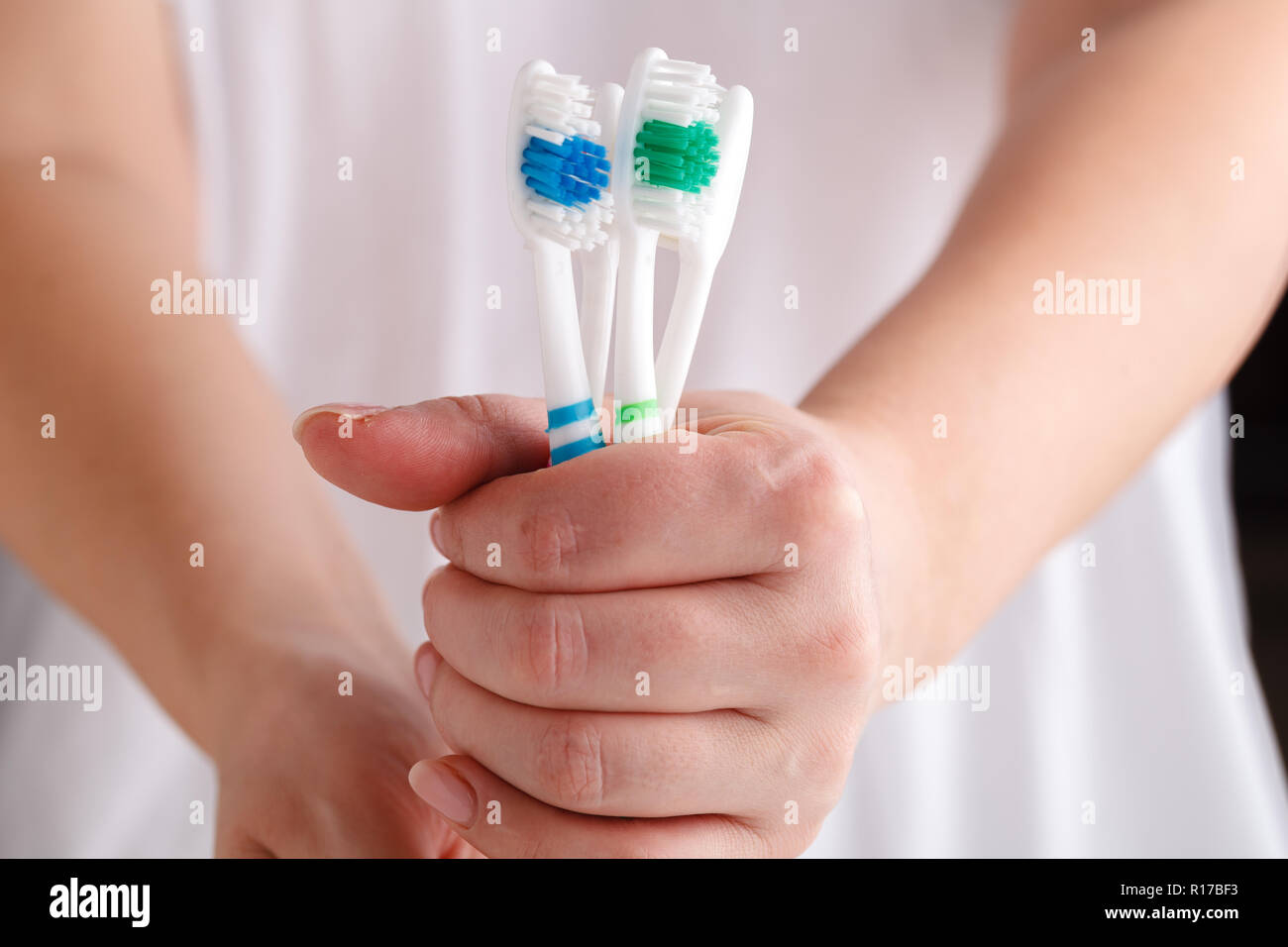 hand holding four toothbrushes of different colors Stock Photo - Alamy