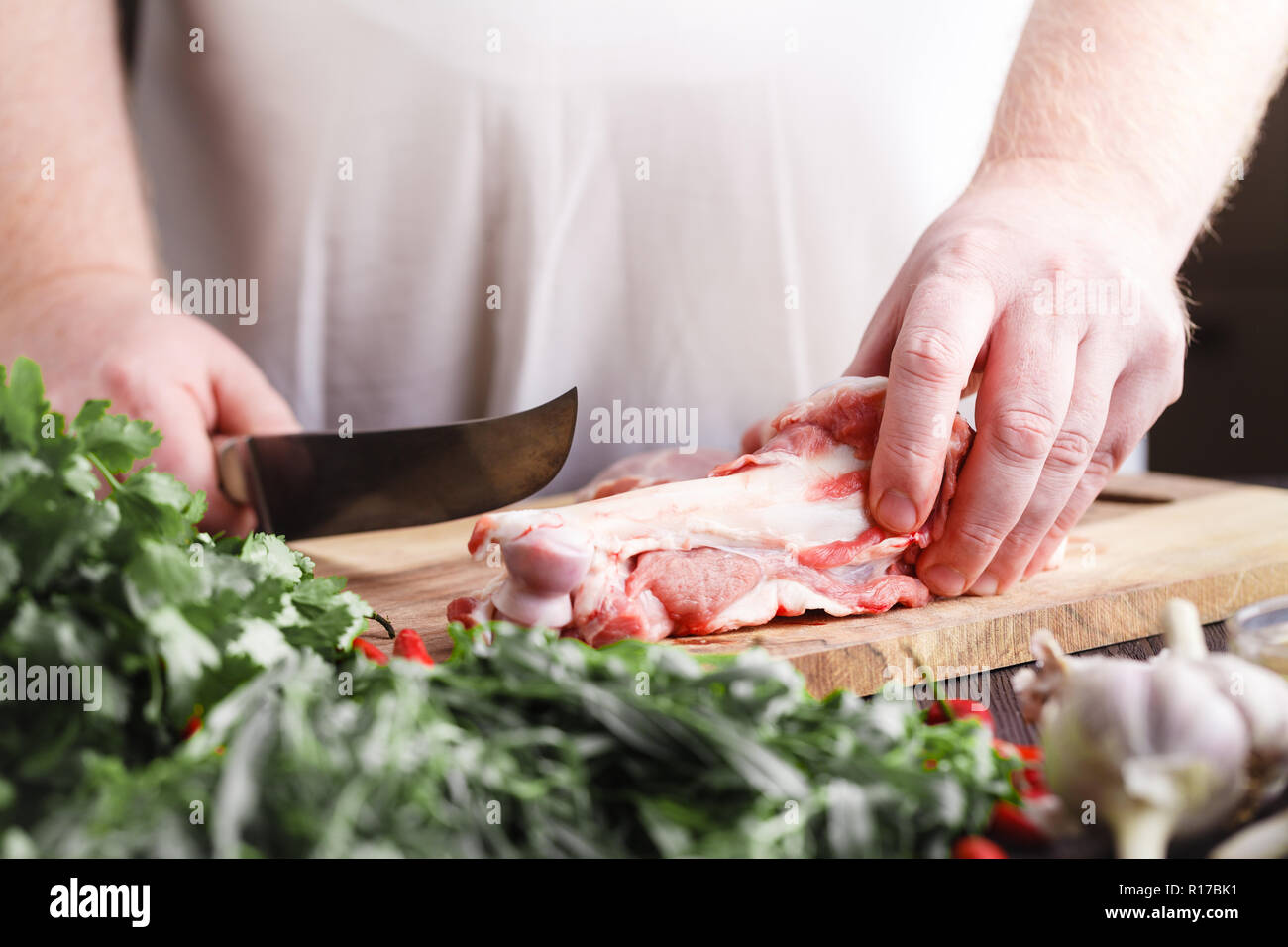 Butcher cutting raw meat on kitchen. Food background for no vegan Stock ...