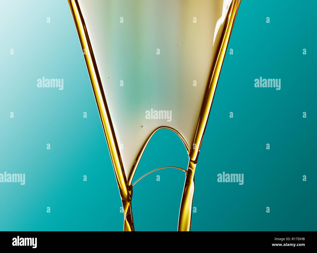 Golden coloured oil flowing into V shape against blue background Stock ...