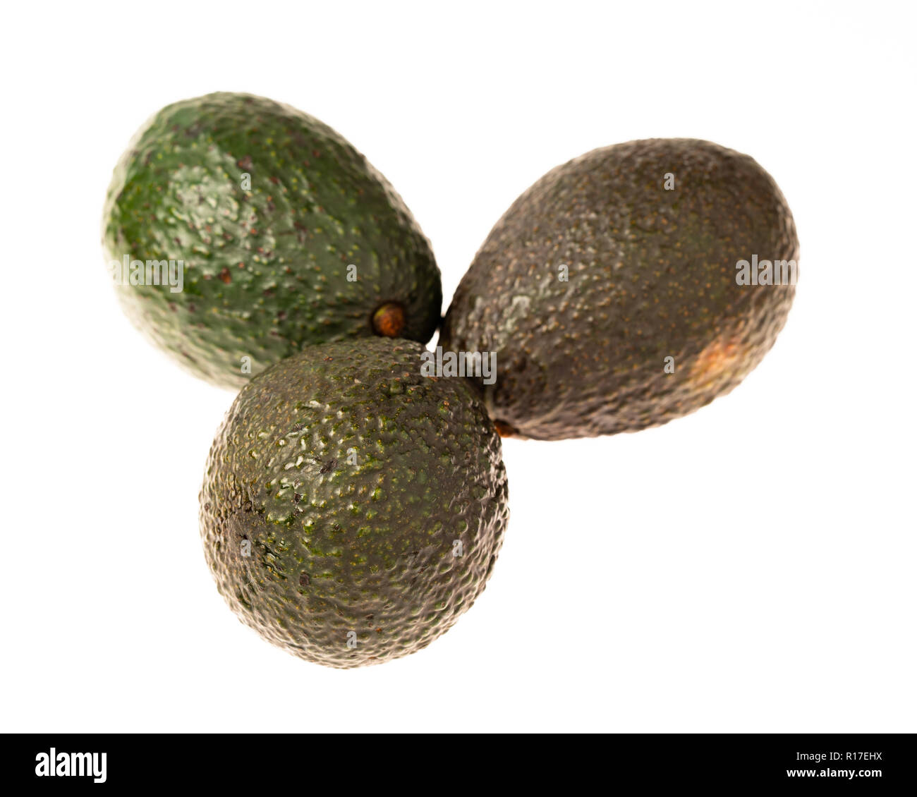 Three avocados arranged on white background Stock Photo - Alamy