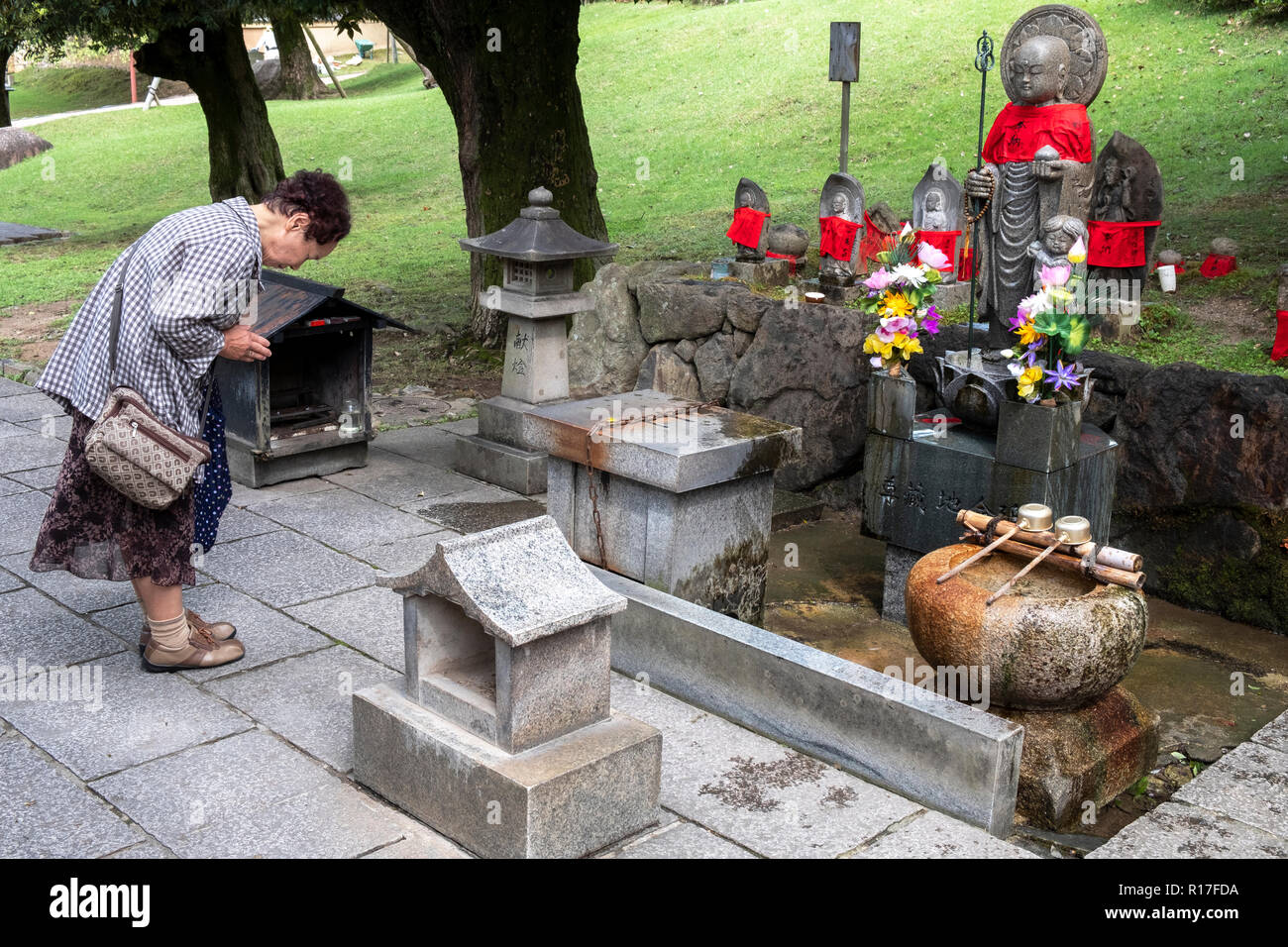 A Japanese woman prays at a shrine outside the Toshodai-ji temple in ...
