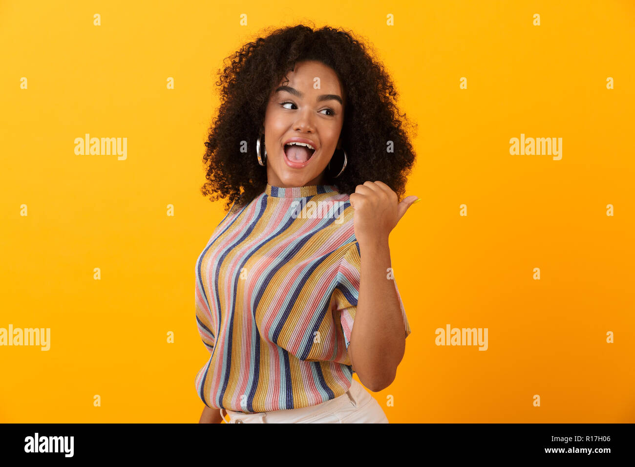 Portrait of a happy african woman standing isolated over yellow ...