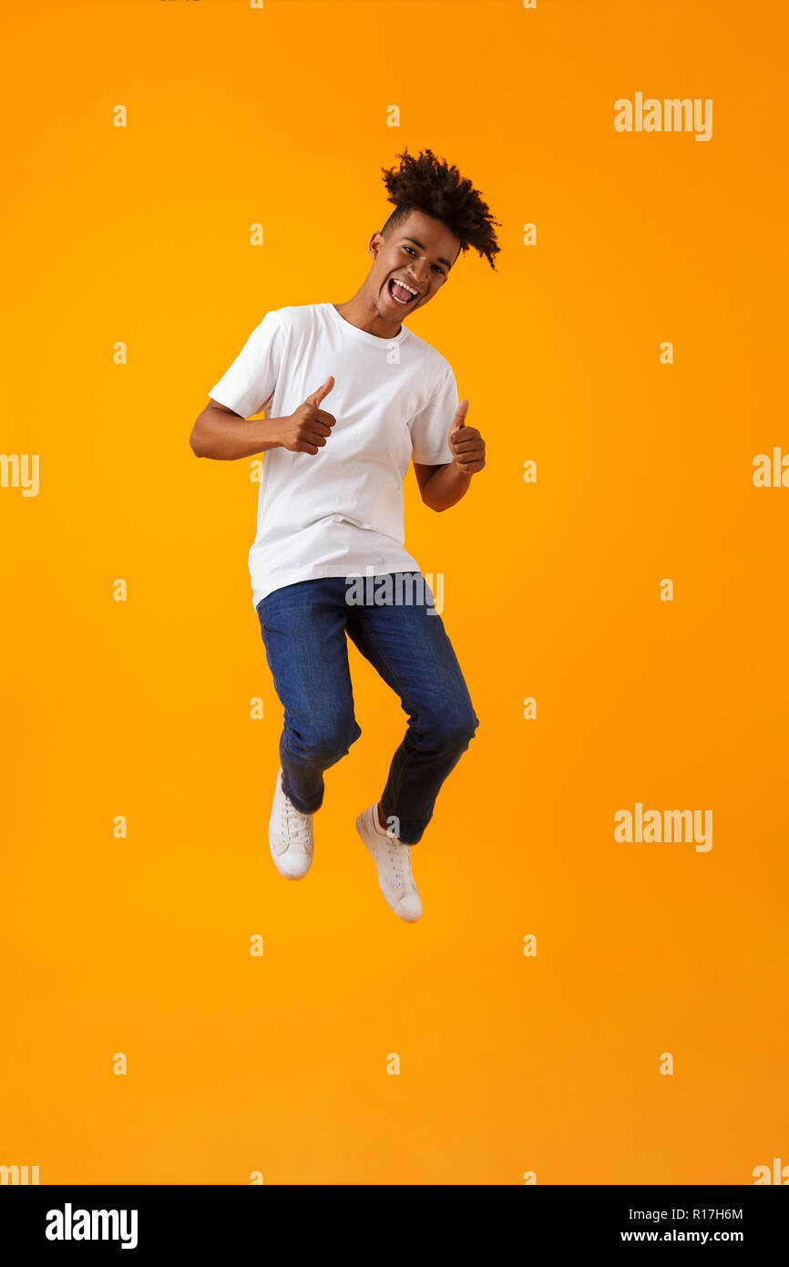 Image of happy young african man jumping isolated over yellow ...