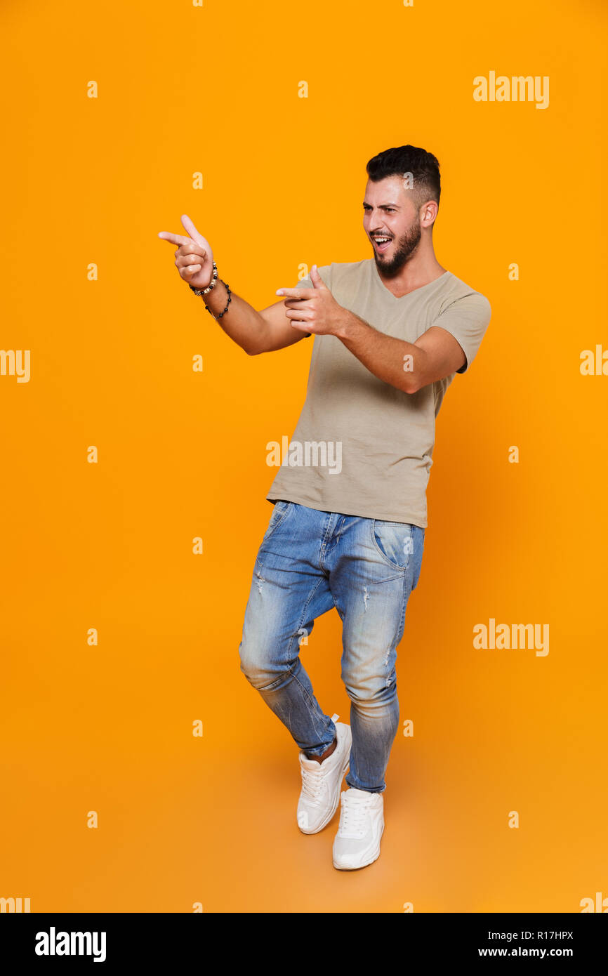 Full length portrait of a smiling young casual man standing isolated ...