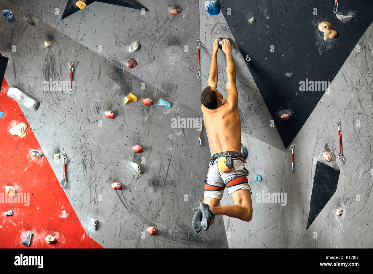 Panoramic man bouldering at an indoor climbing centre Stock Photo - Alamy