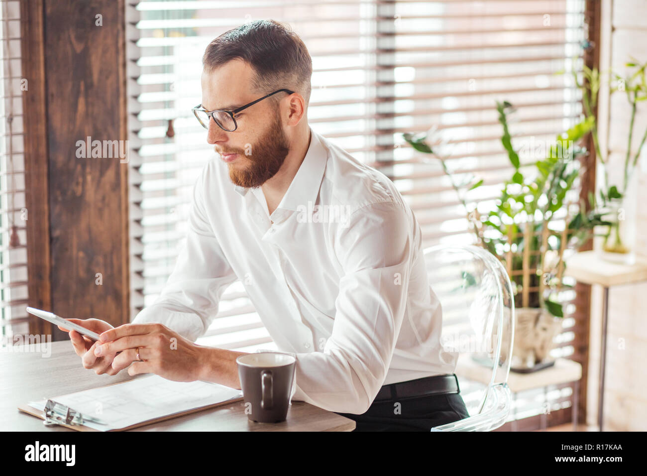 Serious applicant sitting in boardroom, preparing for interview with ...