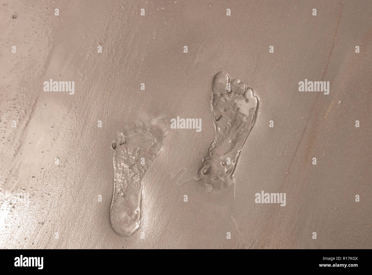 Two foot prints in the sand Stock Photo - Alamy