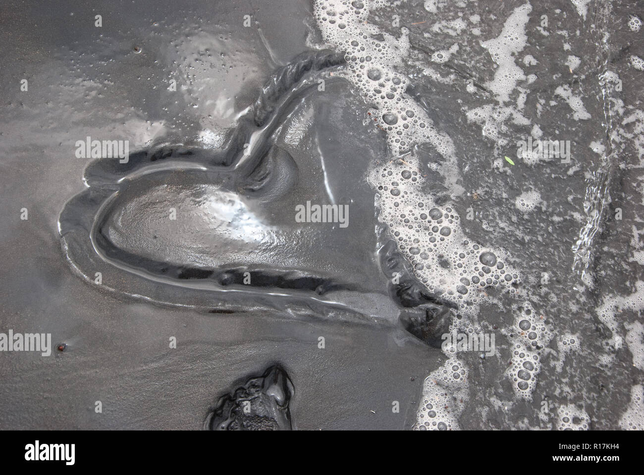 One shiny heart painted in the sandy beach half washed away by the ...