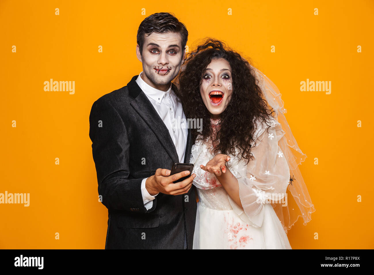 Surprised happy dead bride and groom in hallowen costumes looking ...