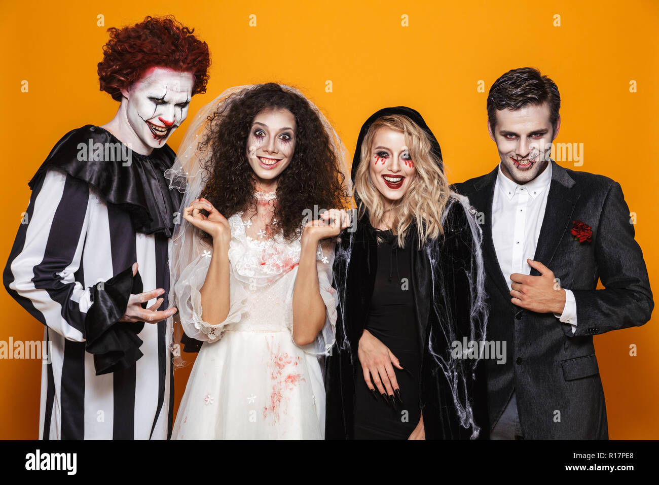 Group of happy friends dressed in scary costumes celebrating Halloween ...