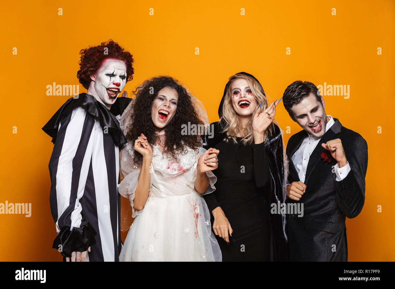 Group of positive friends dressed in scary costumes celebrating ...