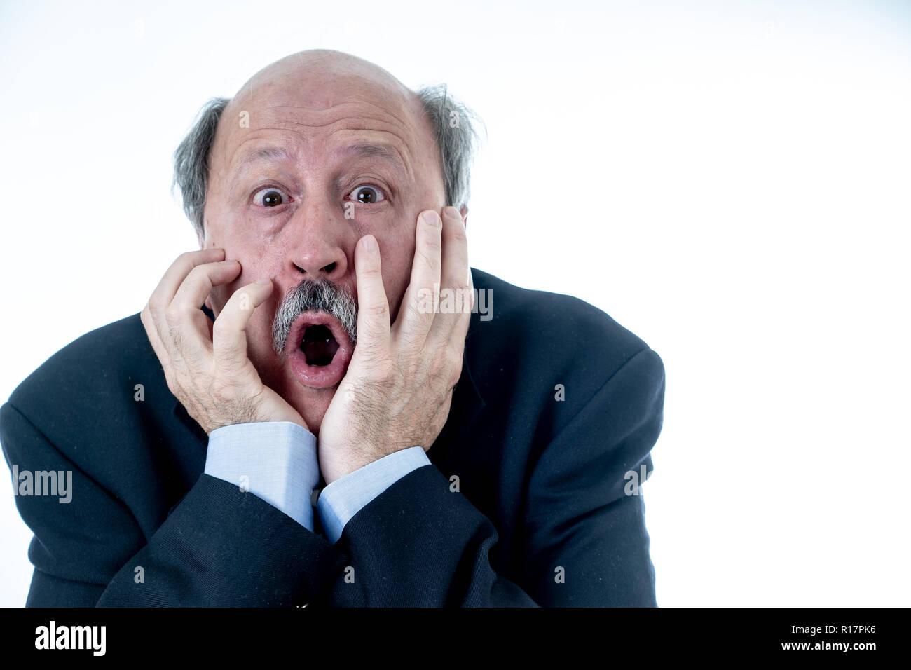 Portrait of a 60s senior man in shock with a scared expression on his ...
