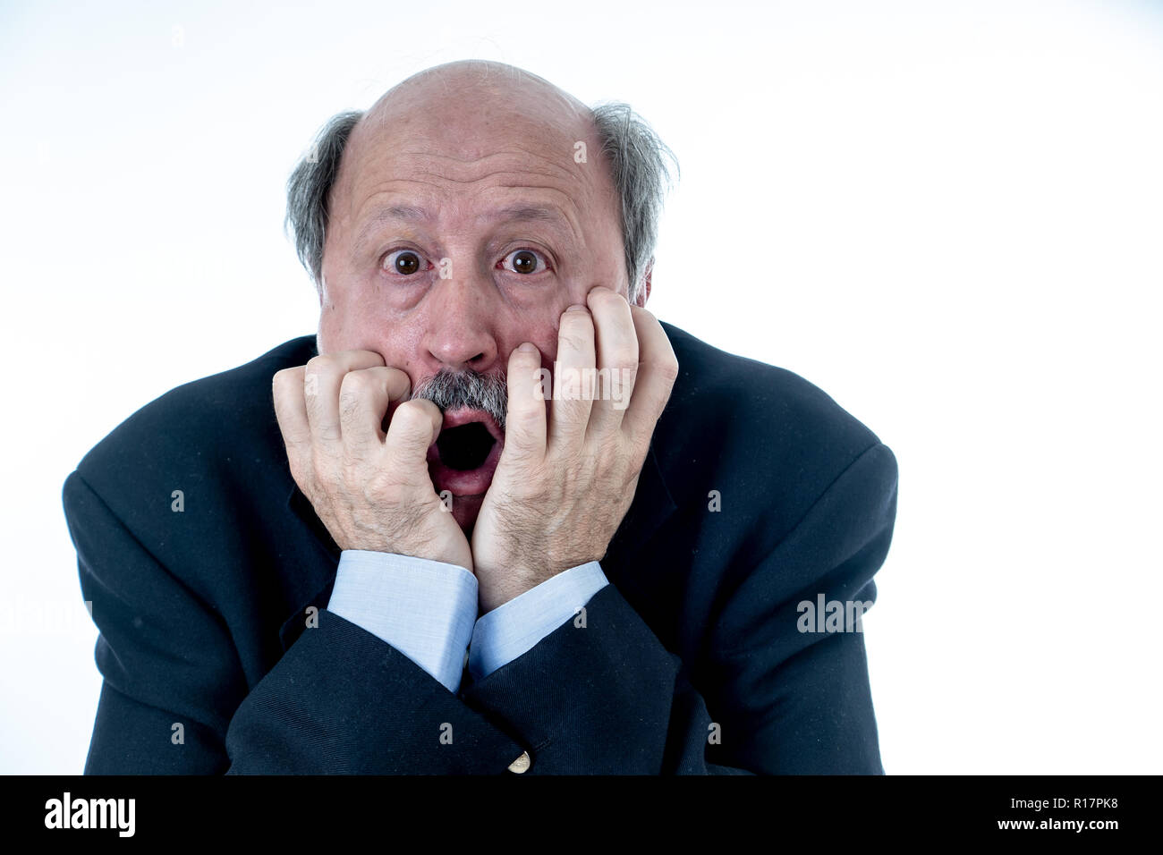 Portrait of a 60s senior man in shock with a scared expression on his ...