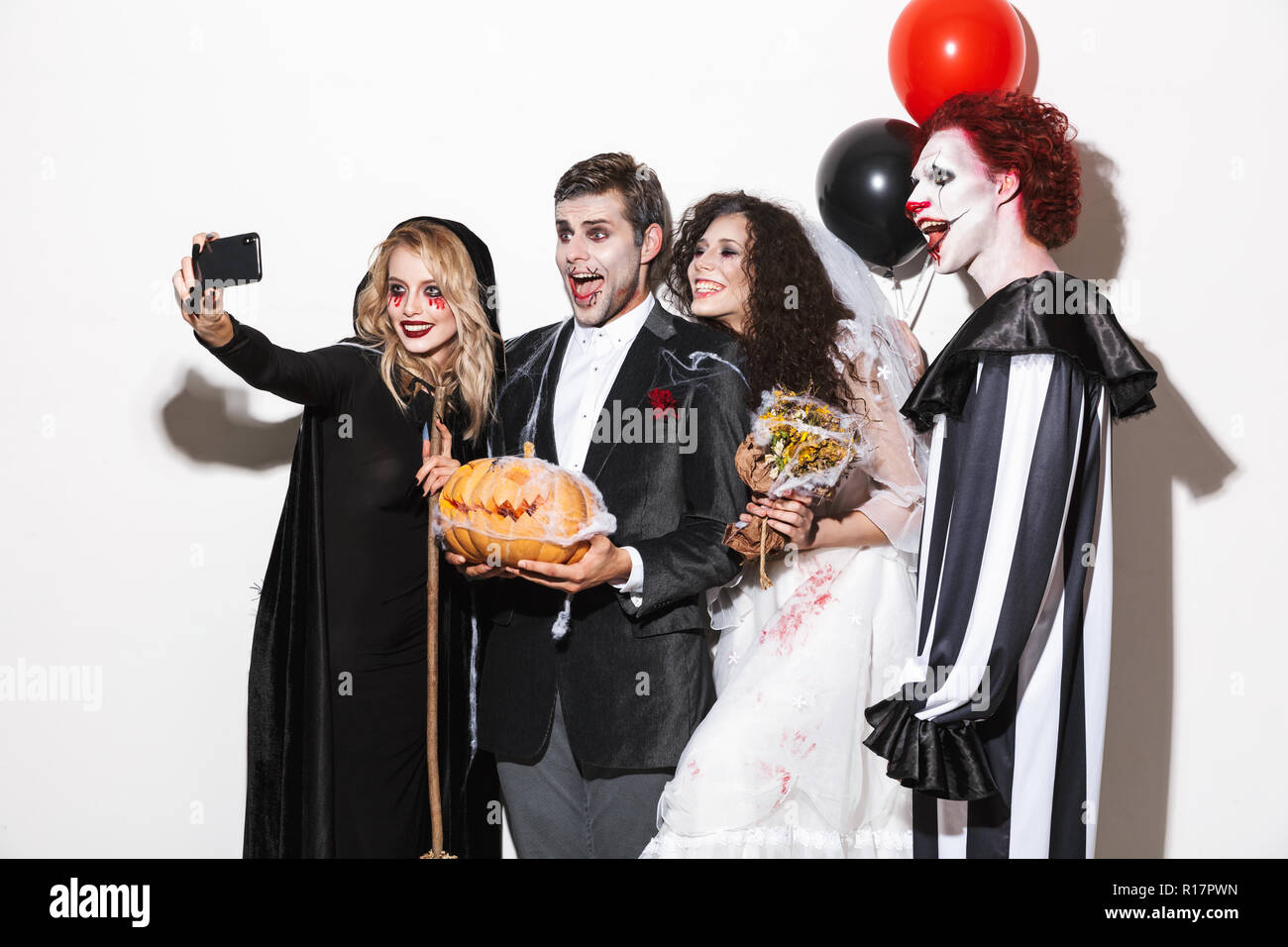Group of happy friends dressed in scary costumes celebrating Halloween ...
