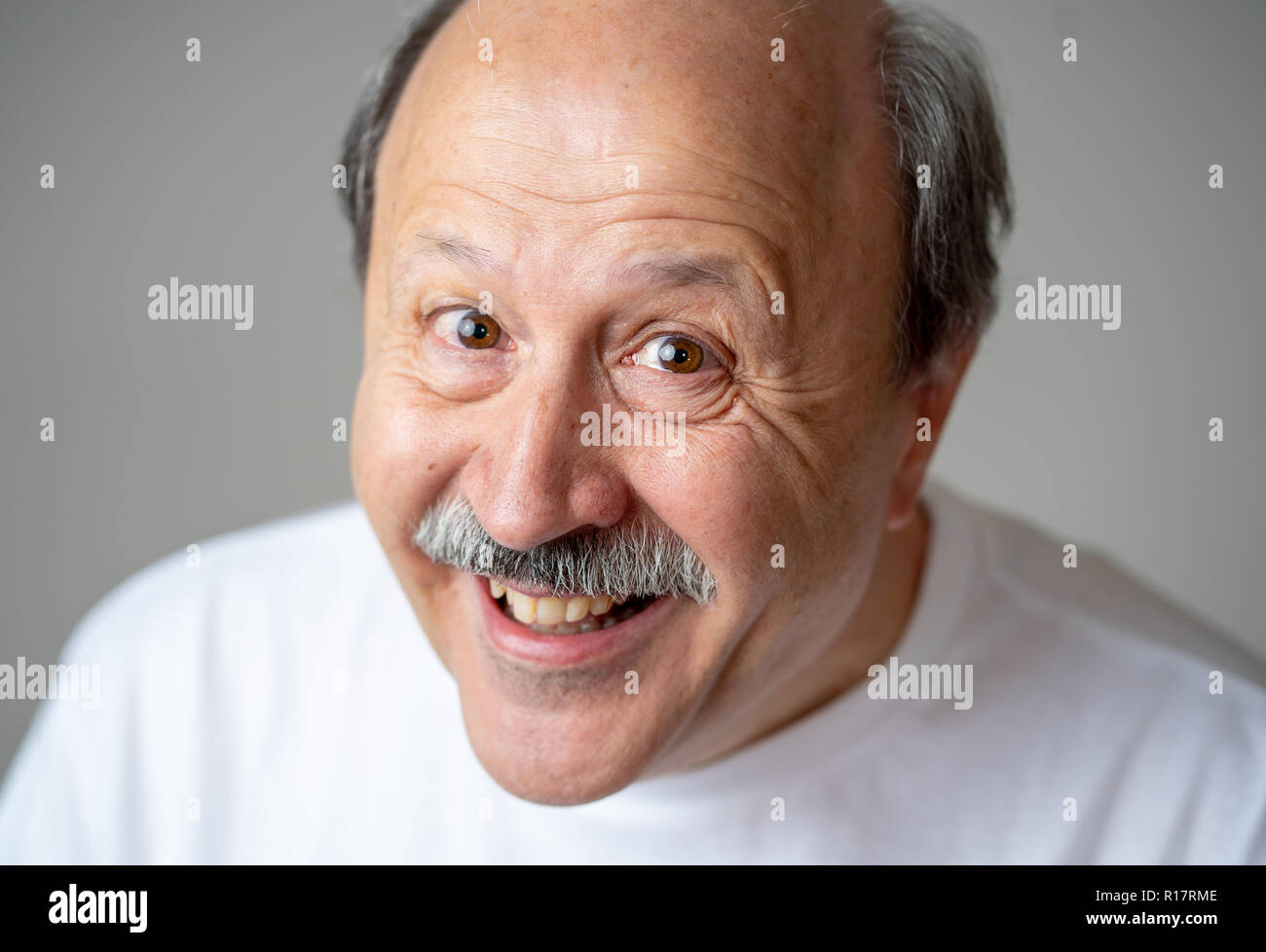 Smiling and laughing 60s year old senior man candid close up portrait ...