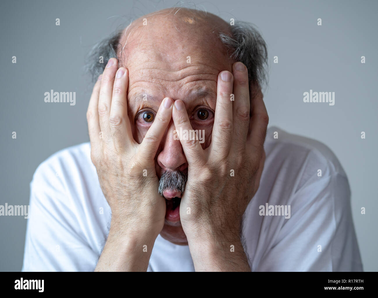 Close up portrait of a scared frightened old man in expression of fear ...