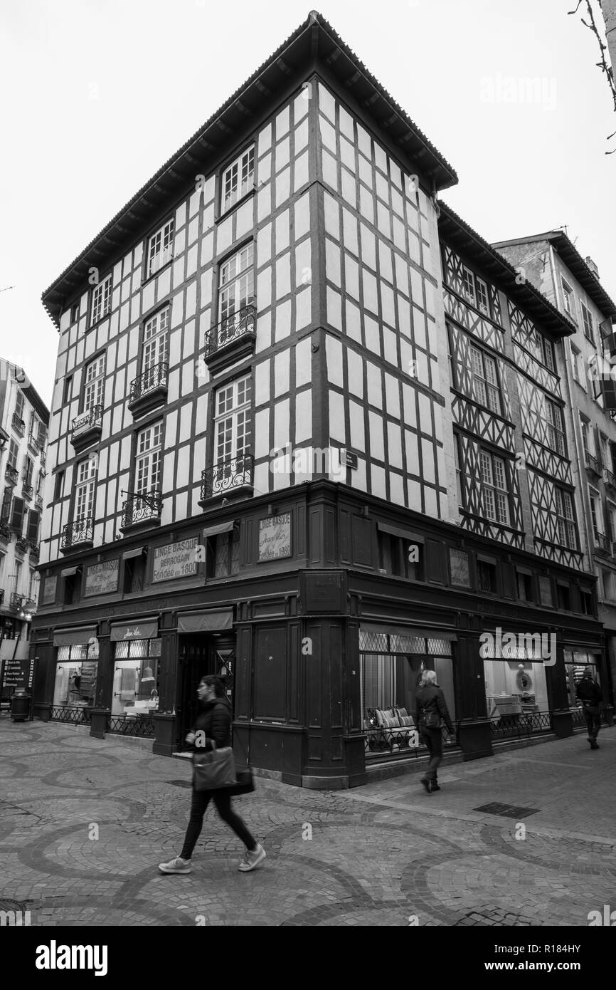 People walking along a street and past a traditional Basque ...