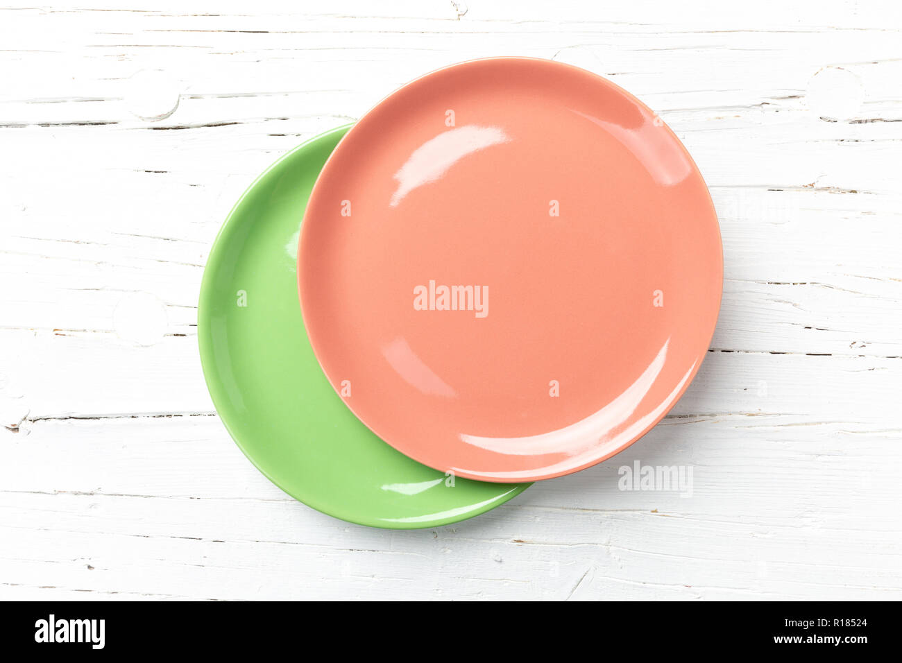 Green and rose pastel colored plates on white wooden background, view ...