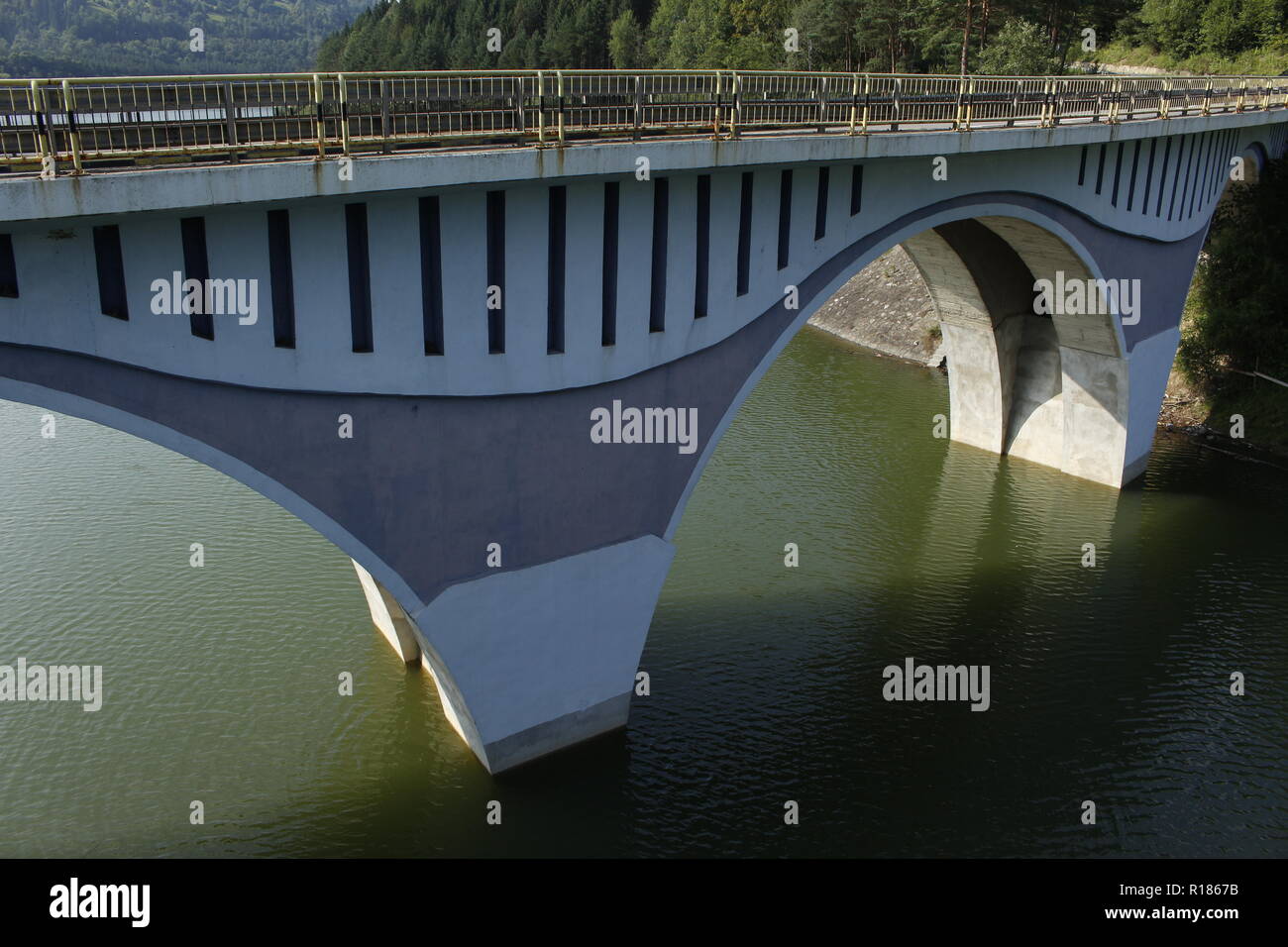 Bridge road in mountain with lake Stock Photo - Alamy