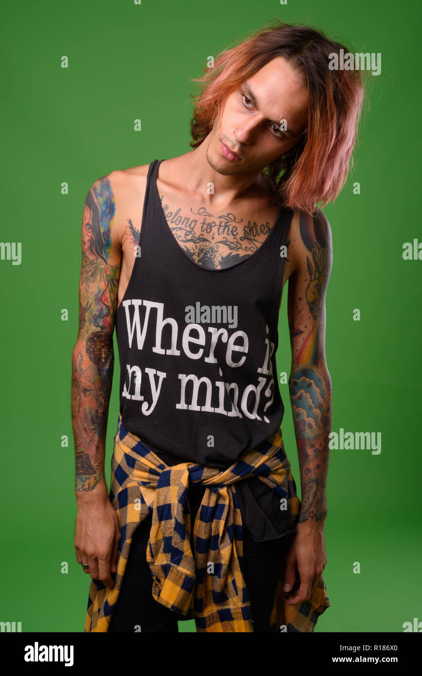 Studio shot of rebellious young man against green background Stock ...