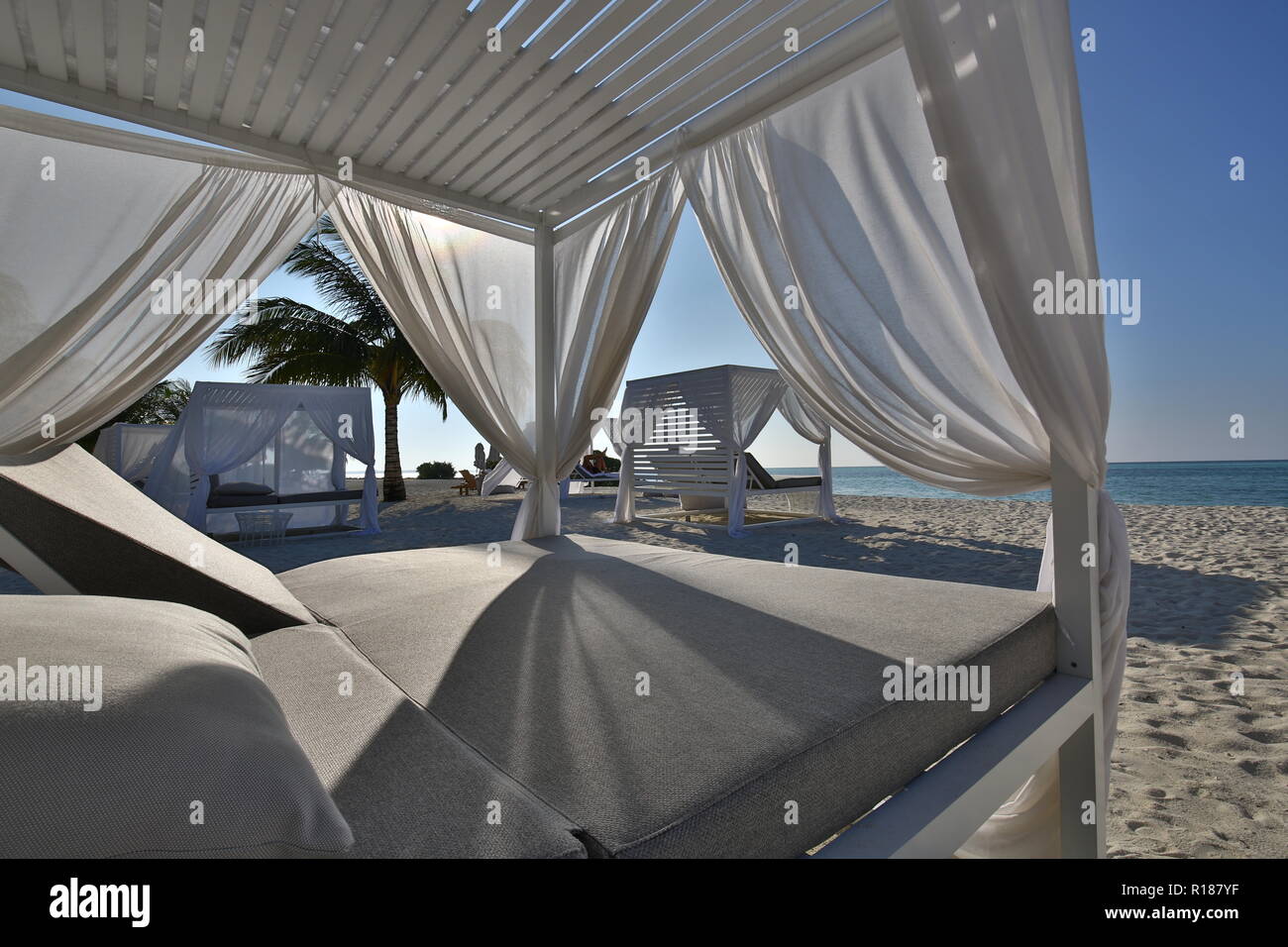 White beach canopies. Luxury beach tents at a resort, white sand with ...