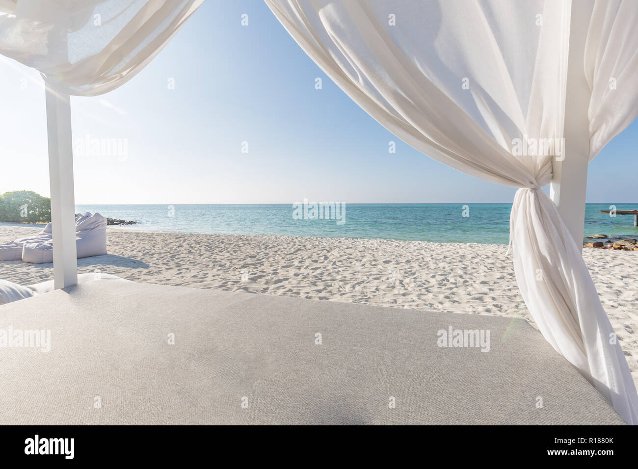 Empty white canopy swing or patio swing by the beach. Luxury vacation ...