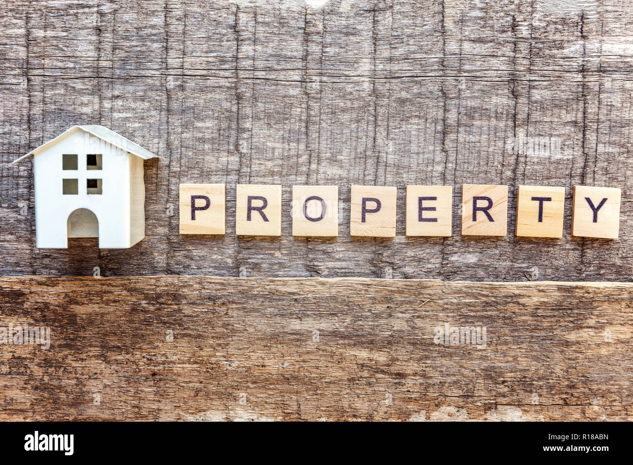 Miniature toy model house with inscription PROPERTY letters word on ...