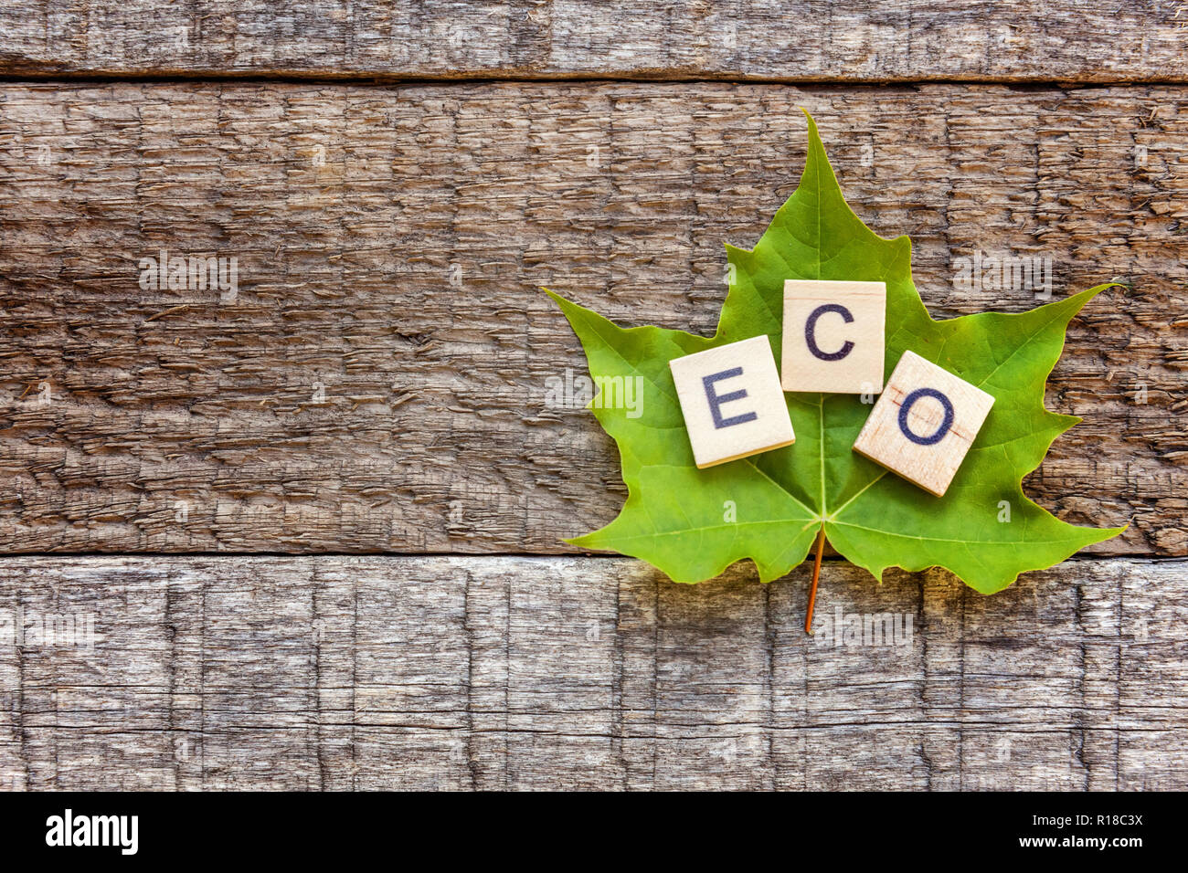 Inscription ECO letters word and maple leaf on old rustic wooden ...