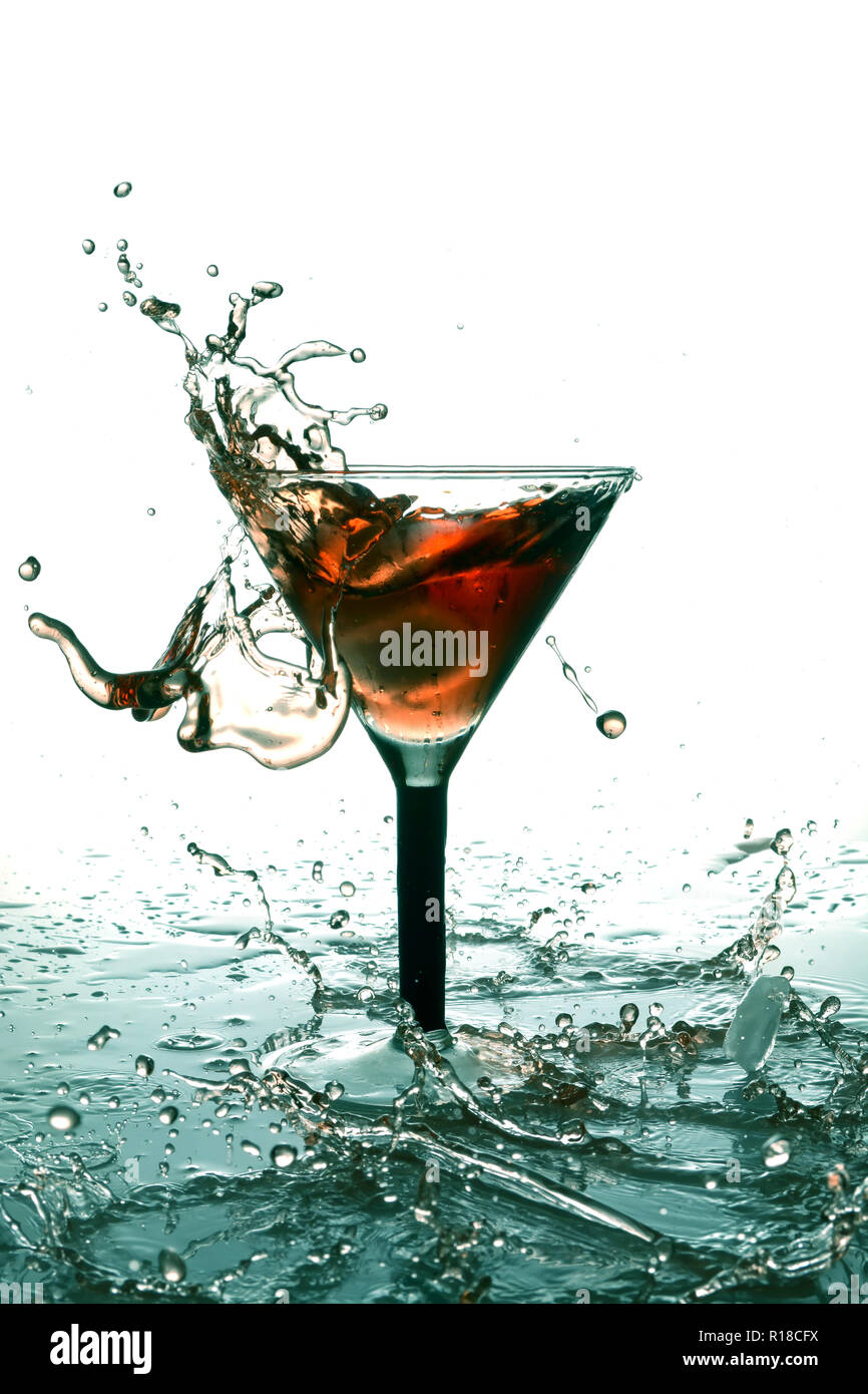 Ice cubes splashing in glass of alcohol and many drops and wave on ...