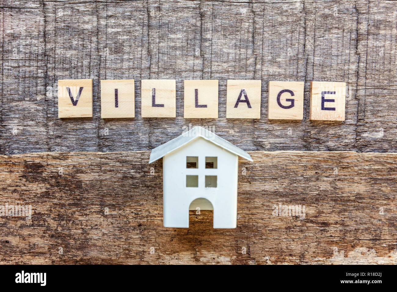 Miniature toy model house with inscription VILLAGE letters word on ...
