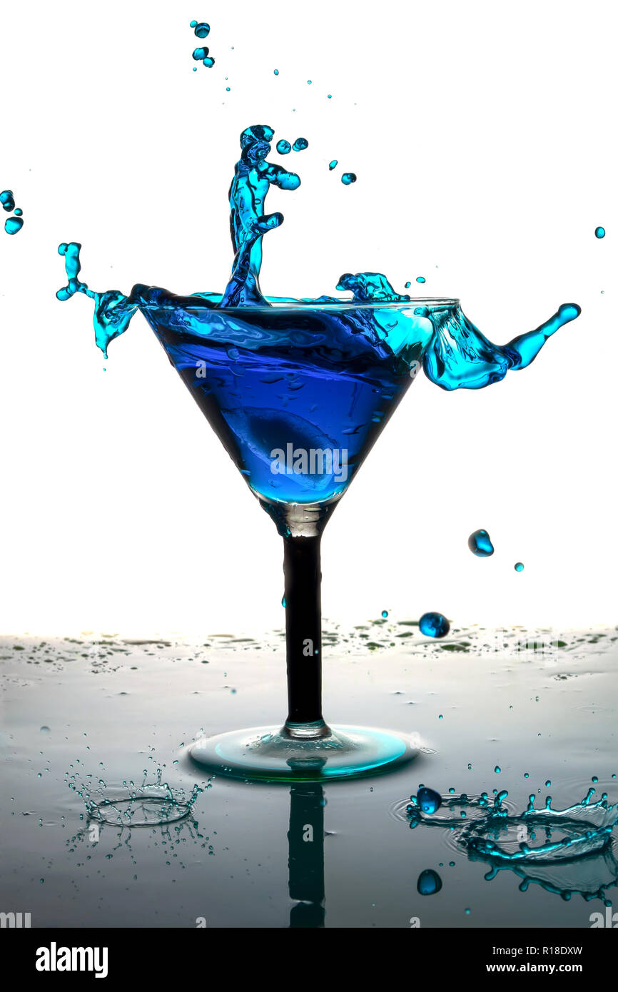 splashing out of the glass blue drink from falling ice cubes Stock Photo - Alamy