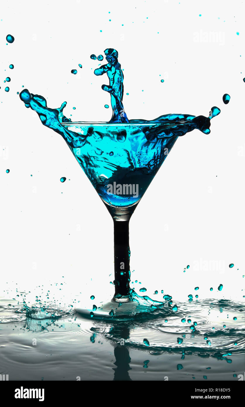 splashing out of the glass blue drink from falling ice cubes Stock Photo - Alamy