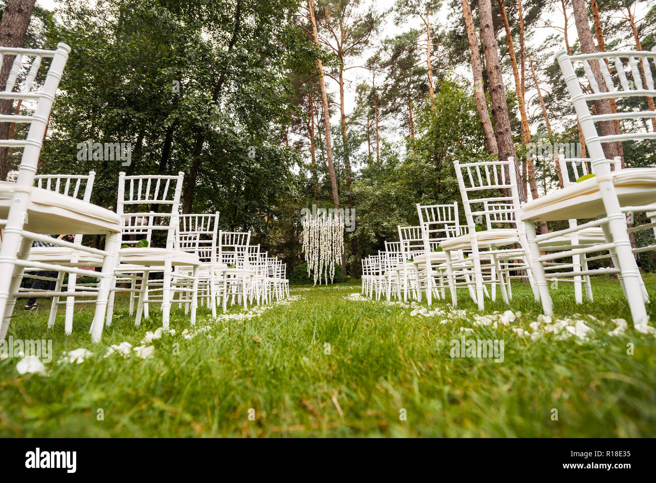 Between rows of white chairs Stock Photo - Alamy