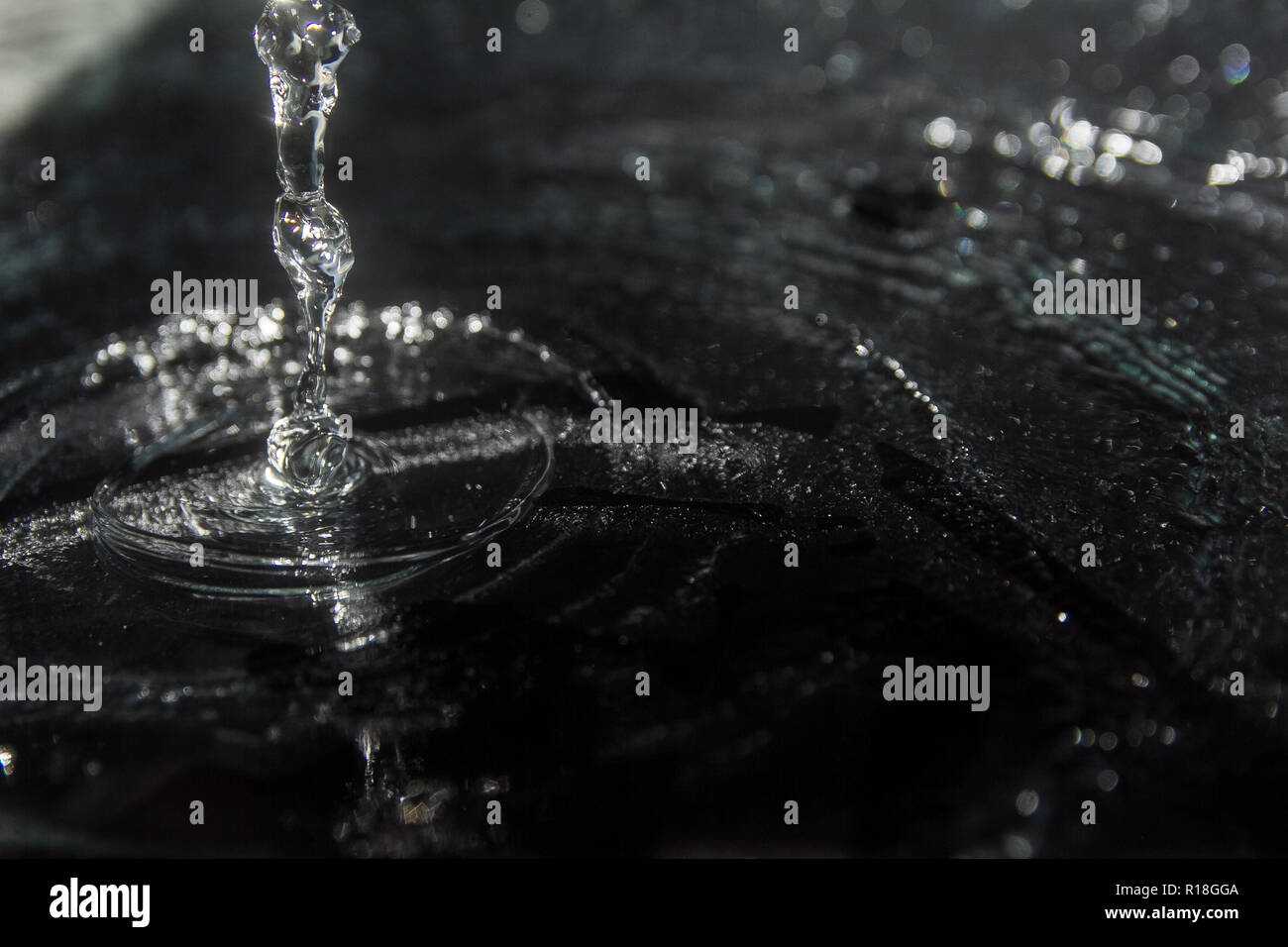 squirt, splash of water on a black background, drops Stock Photo - Alamy
