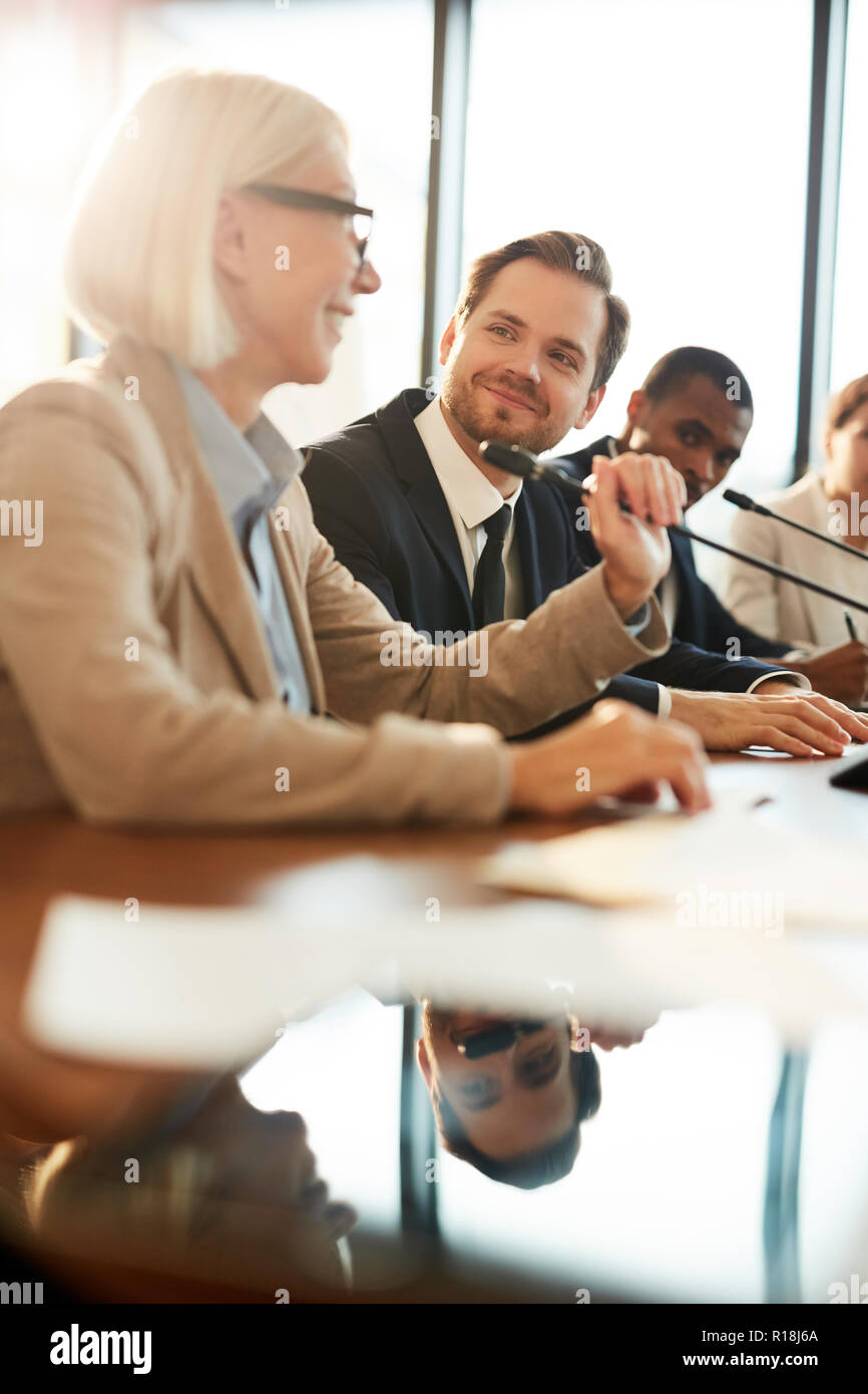 Young confident delegate listening to mature colleague speaking in ...