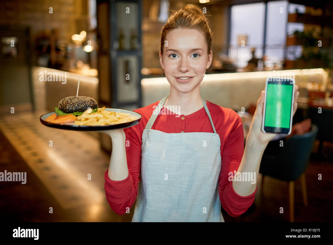 Pretty waitress with order of client showing price of combo in ...