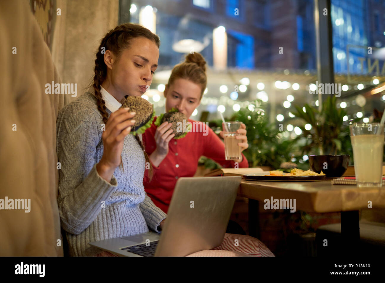 Woman eating hamburger in cafe hi-res stock photography and images - Alamy