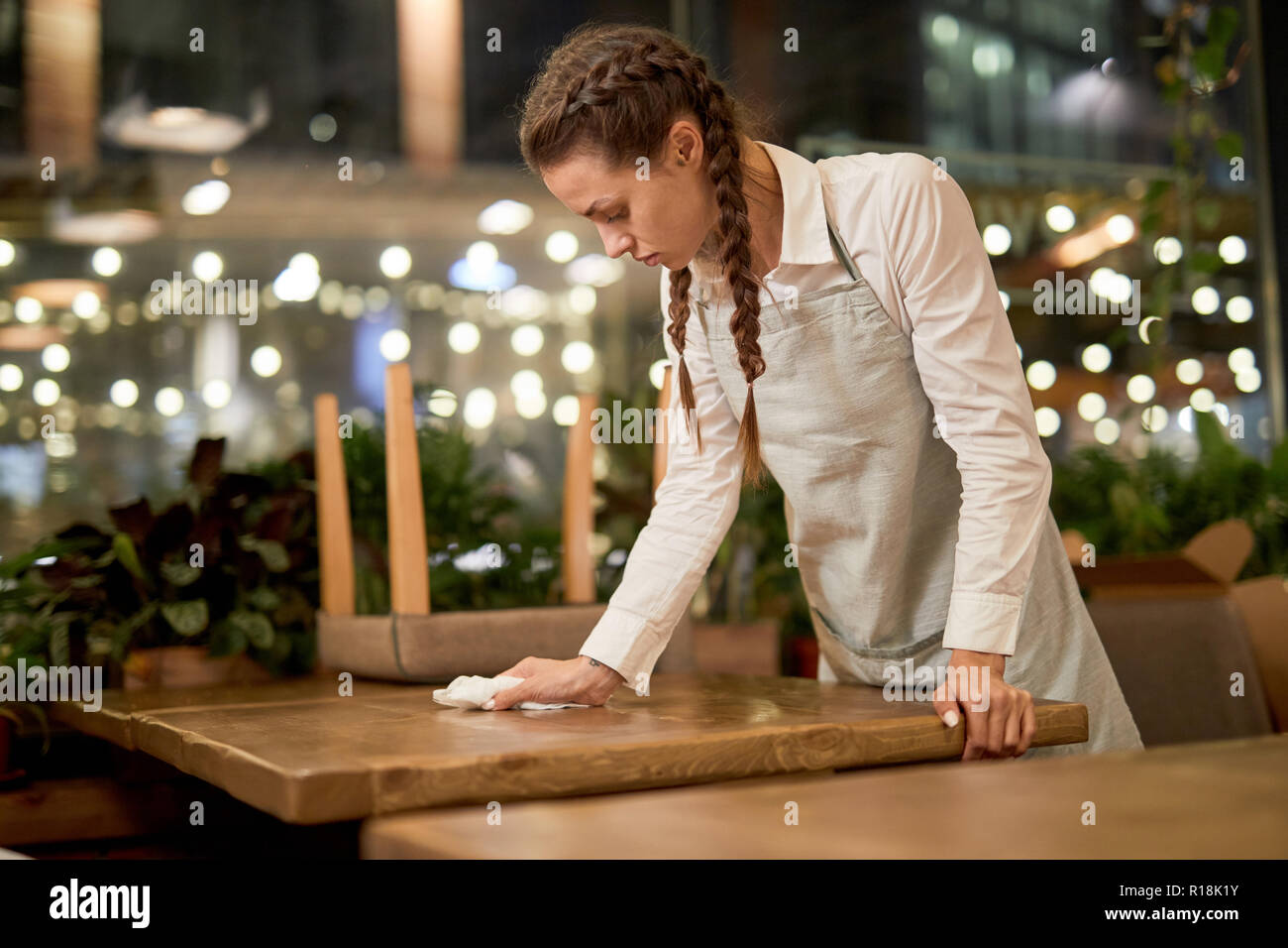 Young waitress wiping table hi-res stock photography and images - Alamy