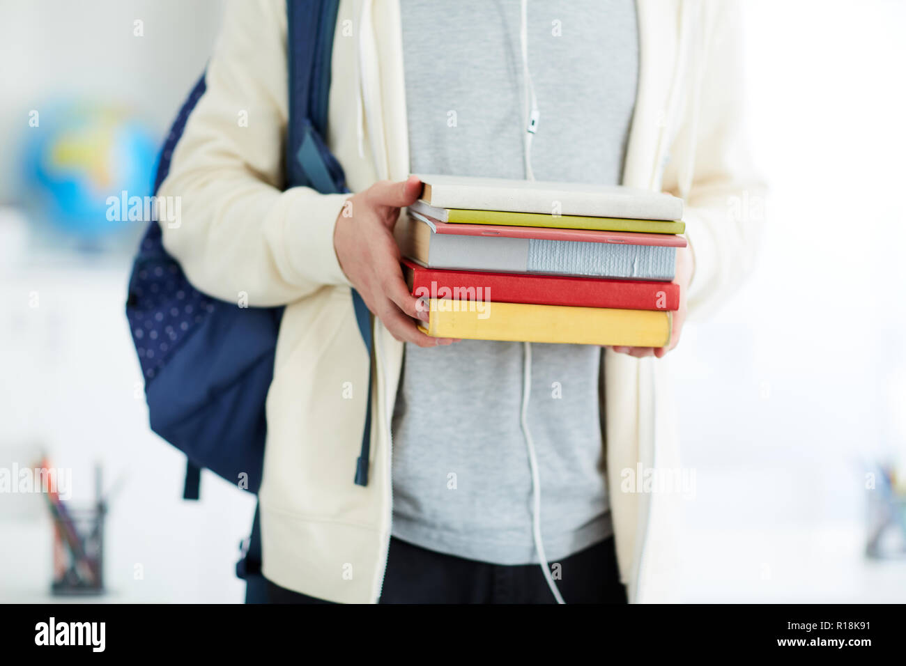 Stack of books and copybooks held by contemporary college student in ...