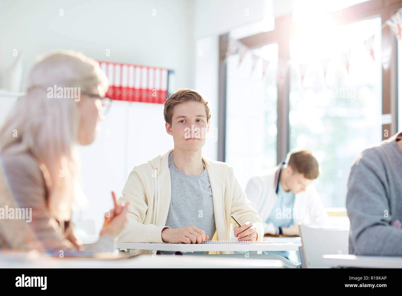 Confused guy looking at pretty groupmate showing him rude gesture at ...