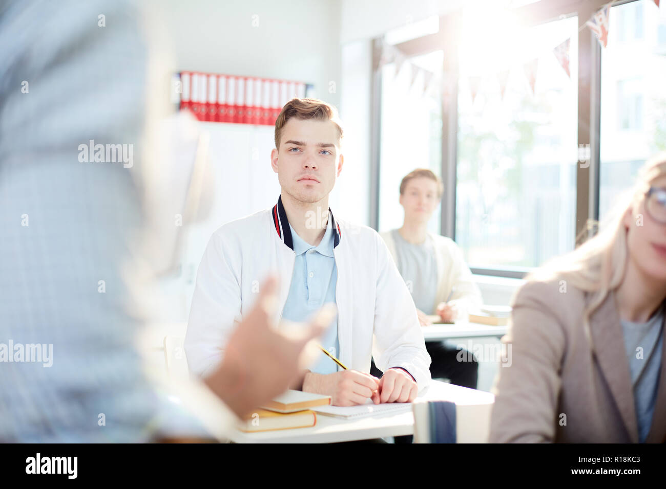 Serious guy listening to teacher answer to his question while making ...