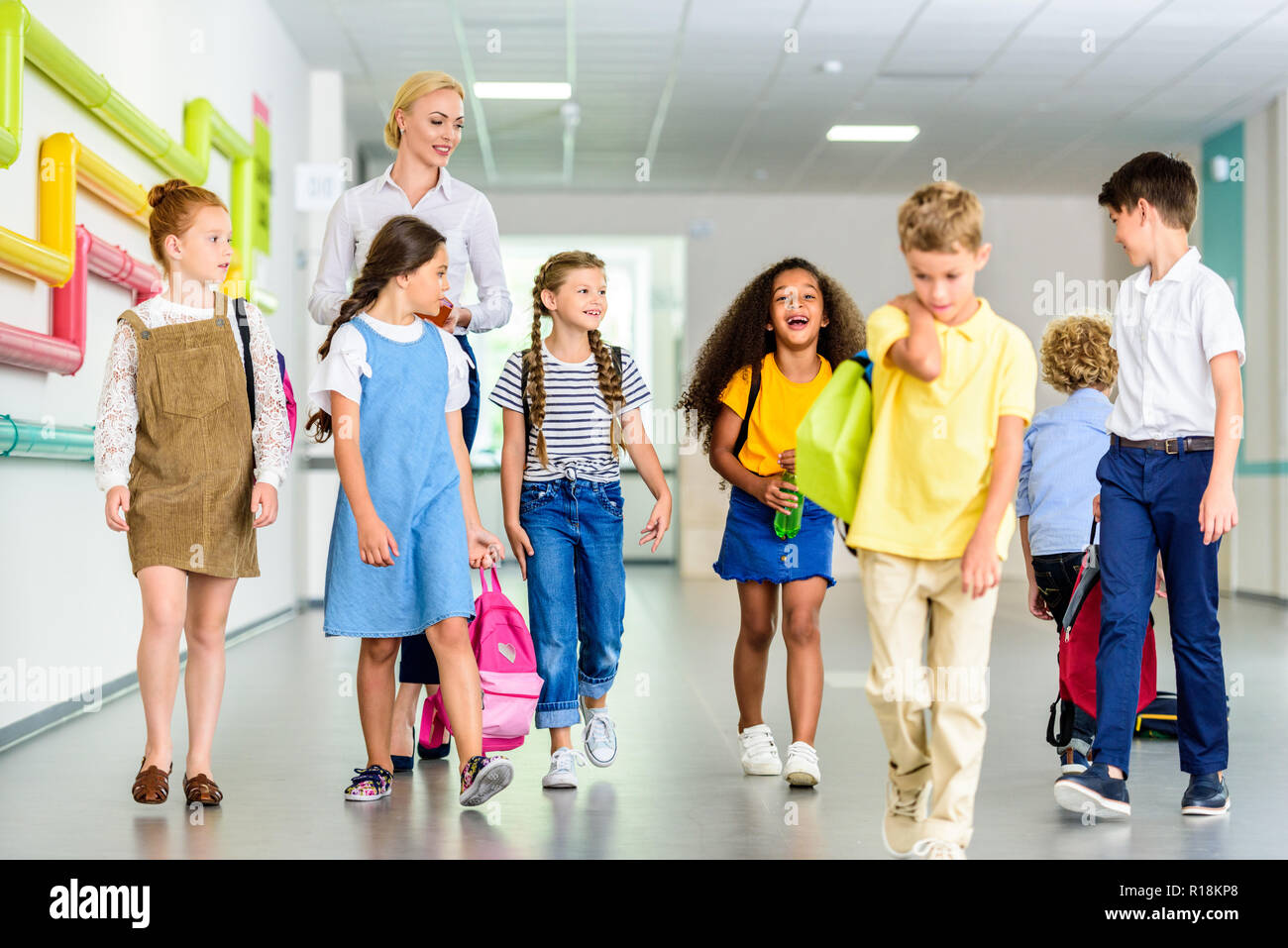 group of happy classmates walking by school corridor Stock Photo - Alamy