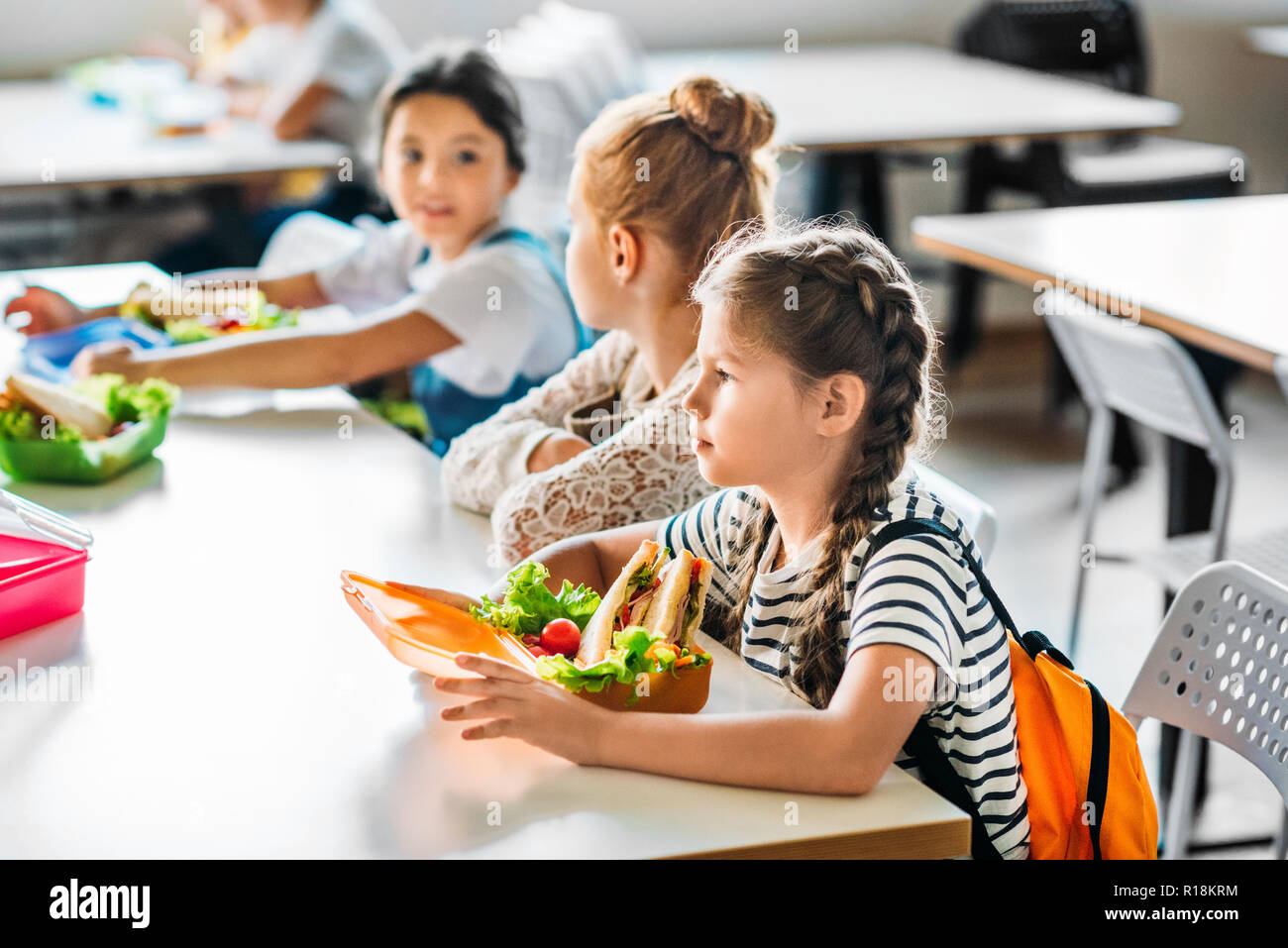 group of schoolgirls taking lunch at school cafeteria together Stock ...