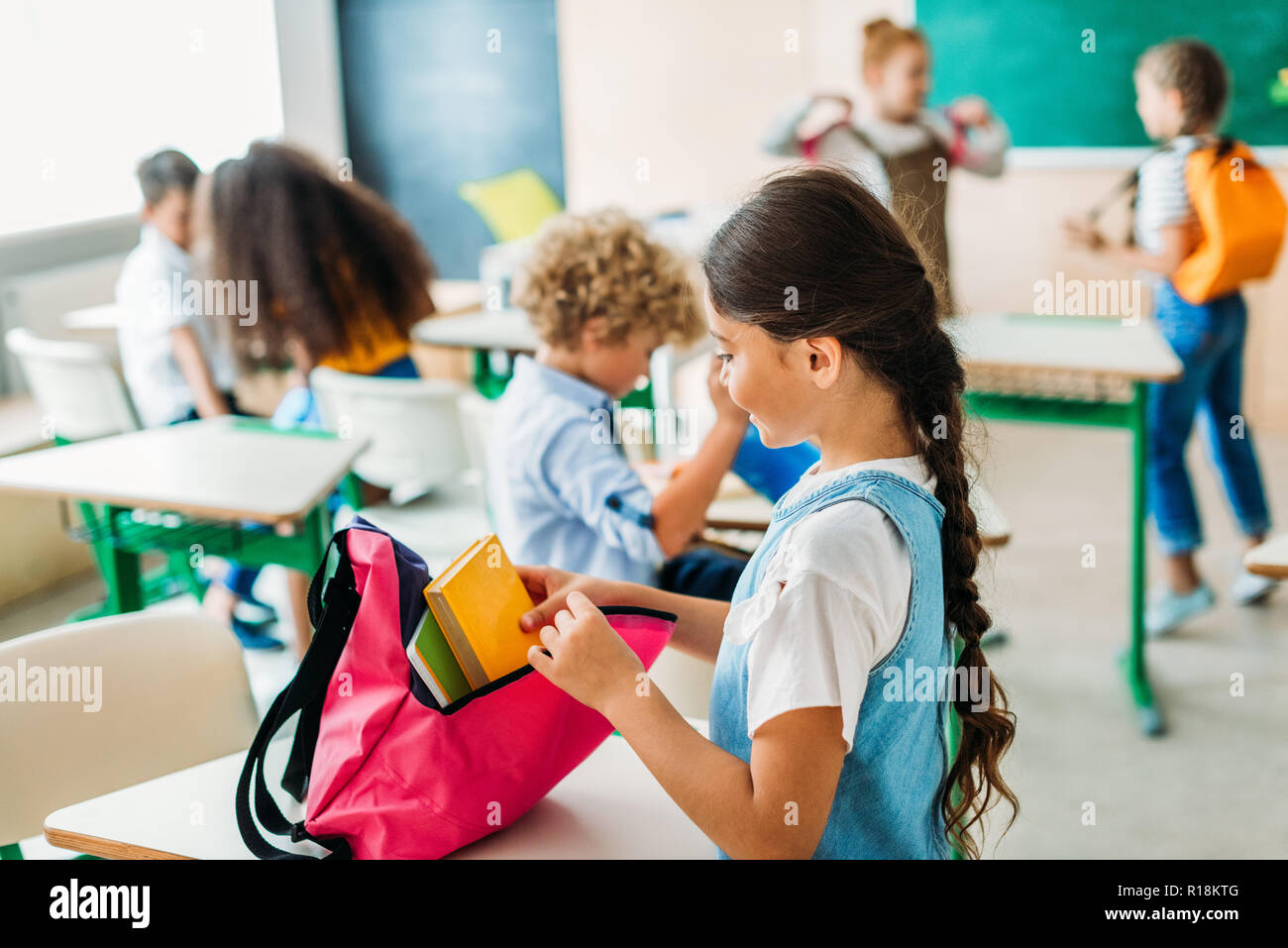 group of schoolchildren preparing for lesson at classroom Stock Photo ...